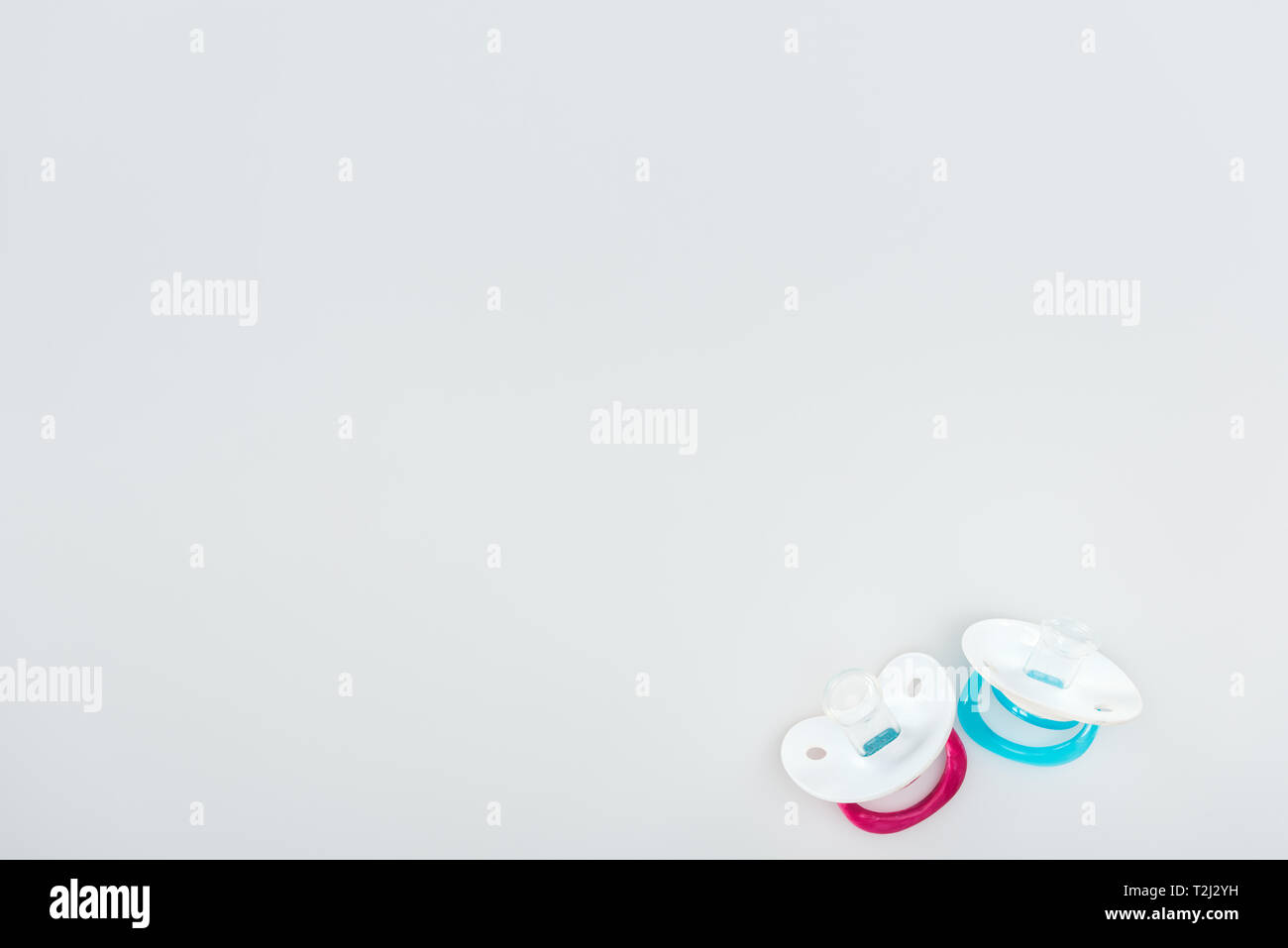 top view of pink and blue pacifiers isolated on white with copy space ...