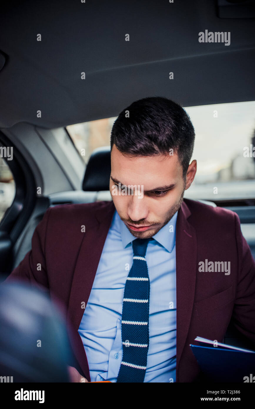 A good looking businessman is driving in a stretch limo Stock Photo - Alamy