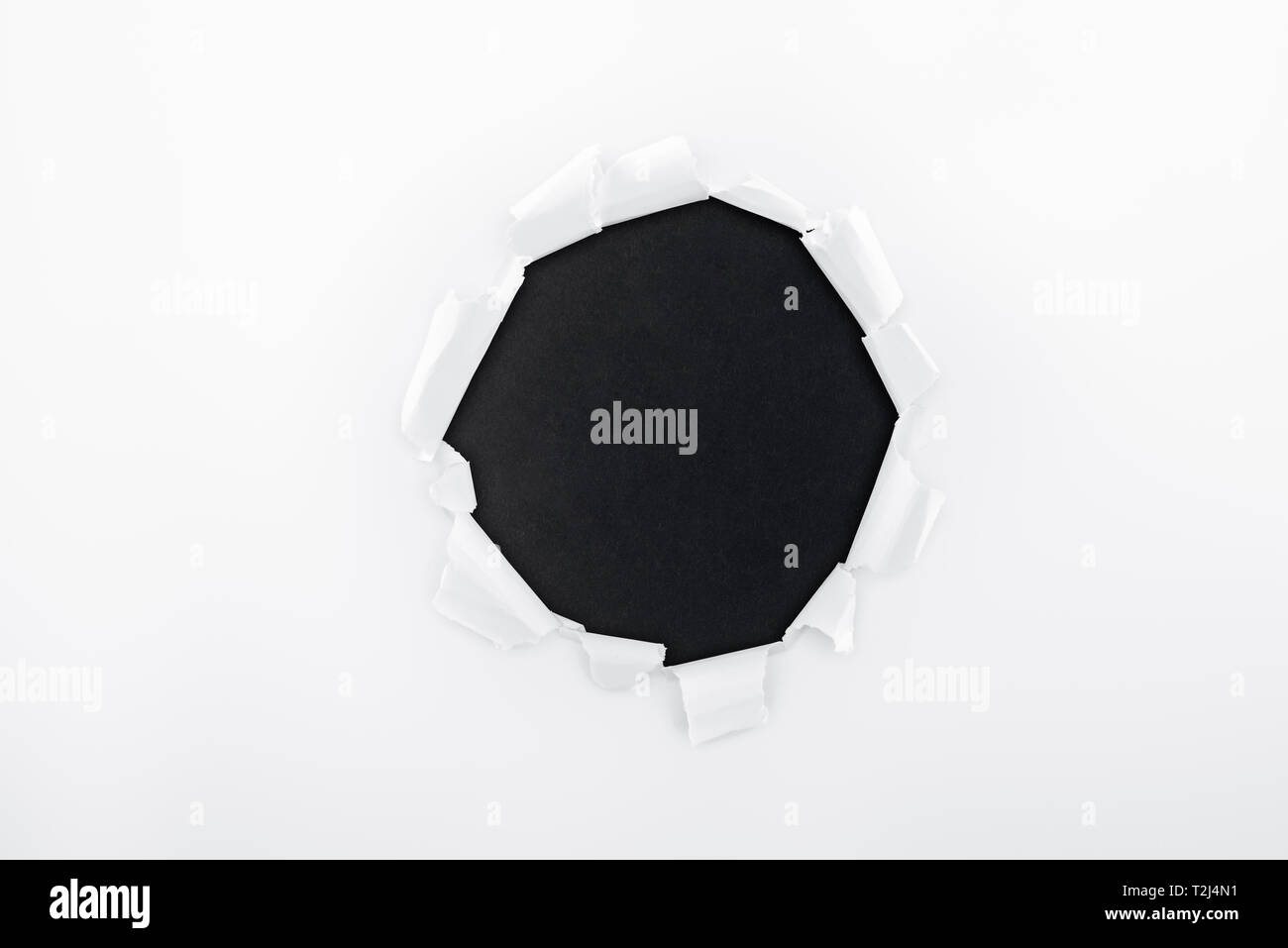 ragged hole in textured white paper on black background Stock Photo - Alamy
