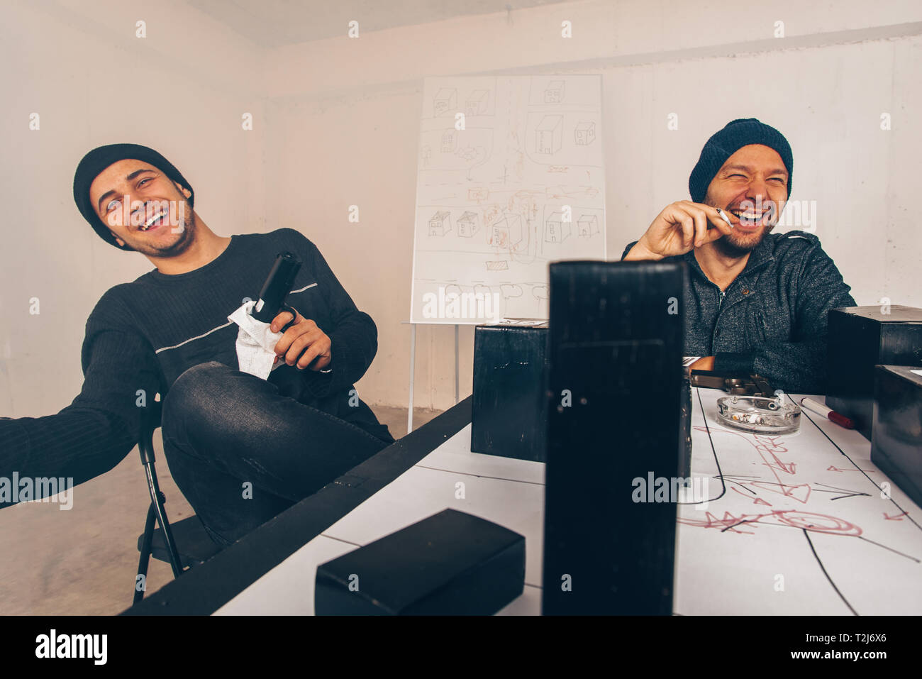 Two thiefs are sitting in a room, smiling and planning a heist Stock ...