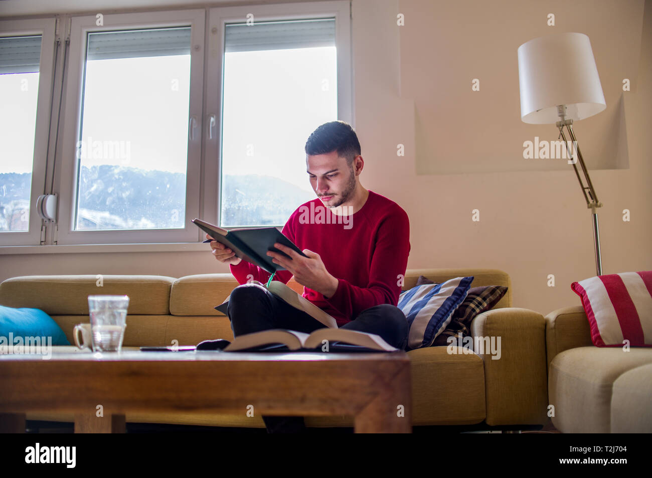 Young stressed student man studying pile of books on library desk ... Young stressed student man studying pile of books on library desk ...