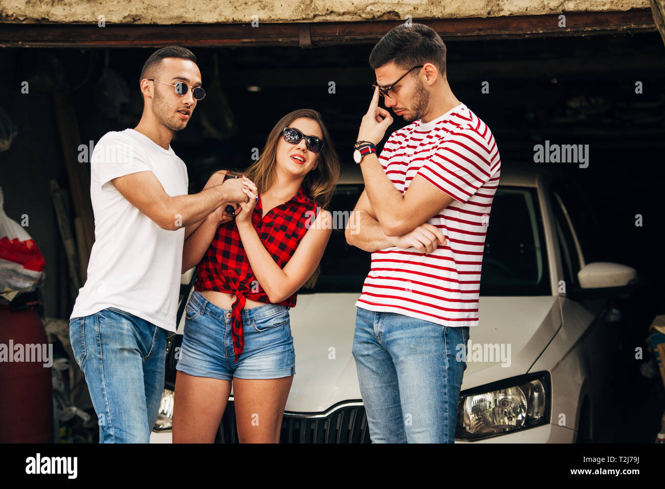 Three young people looking serious having conversation outside Stock ...
