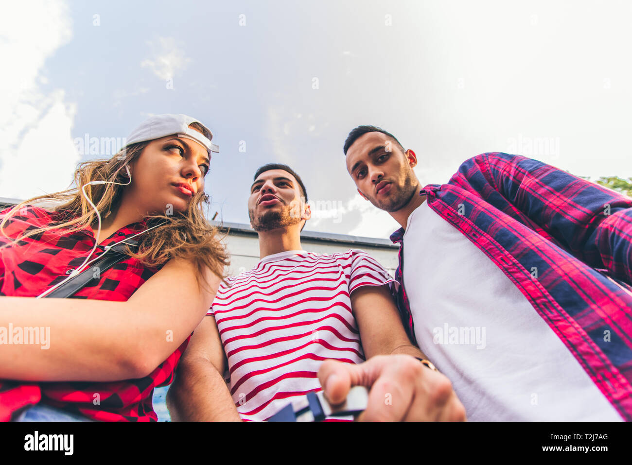 Three friends are fooling around and having fun while posing outside ...
