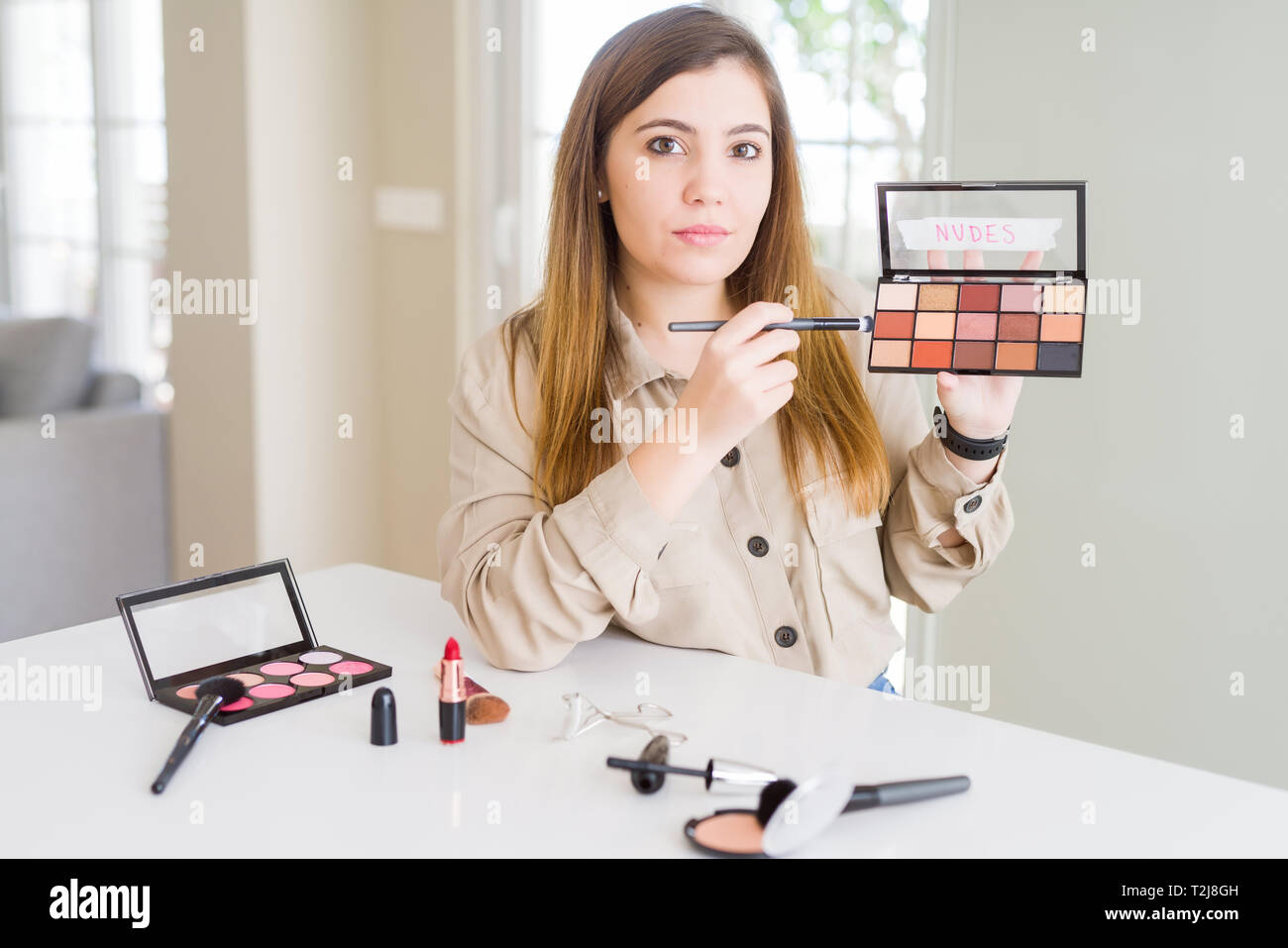 Beautiful young woman using make up cosmetics applying color from ...