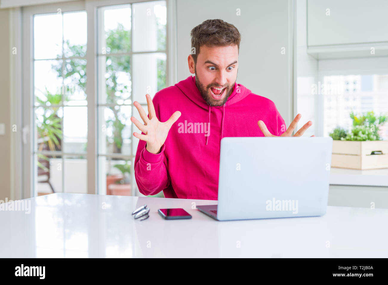 Handsome man working using computer laptop celebrating crazy and amazed ...