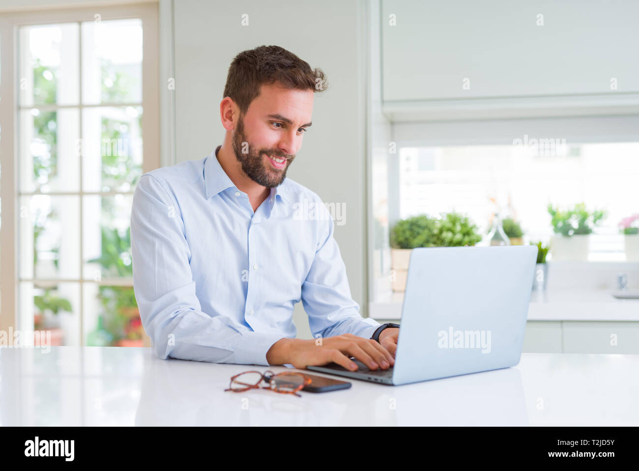 Handsome business man working using computer laptop with a happy face ...