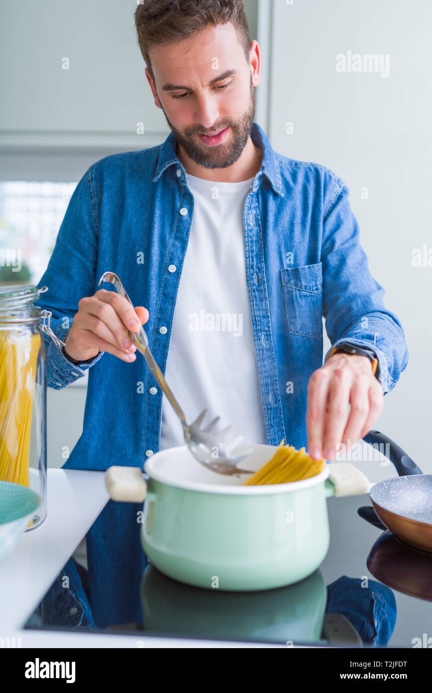 Handsome man cooking pasta at home Stock Photo - Alamy