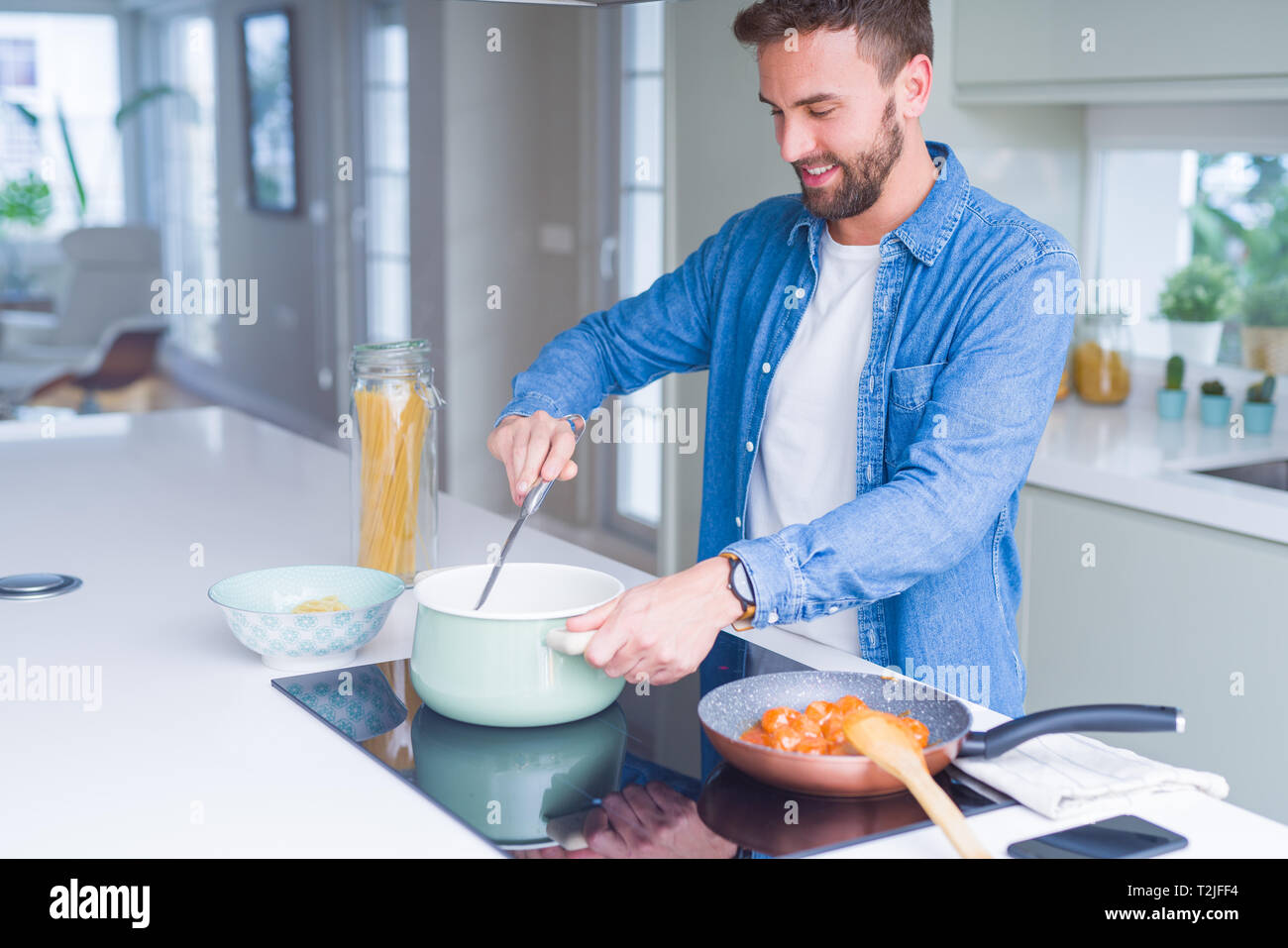 Handsome man cooking pasta at home Stock Photo - Alamy