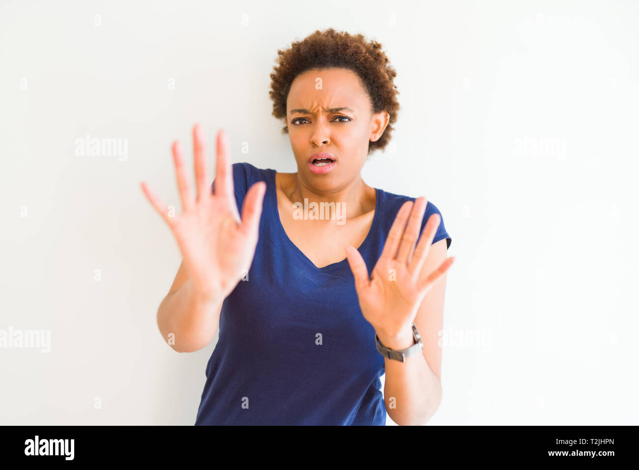 Young beautiful african american woman over white background afraid and ...