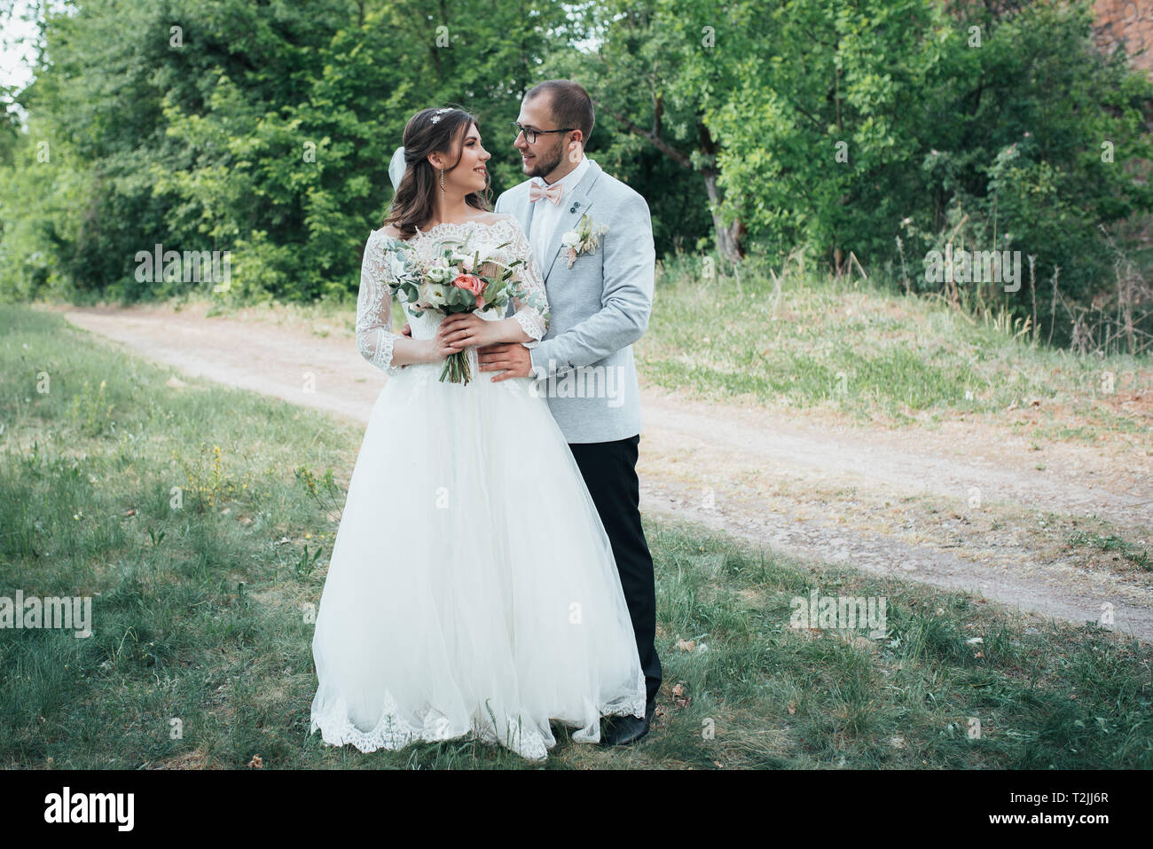 Wedding photo of the bride and groom in a gray-pink color on nature in ...