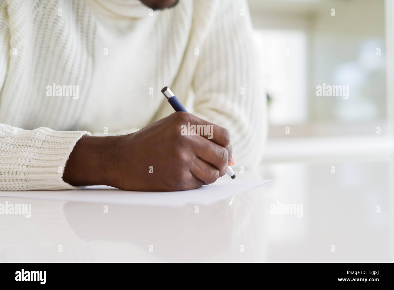 Close up of african man writing a note on a paper Stock Photo - Alamy
