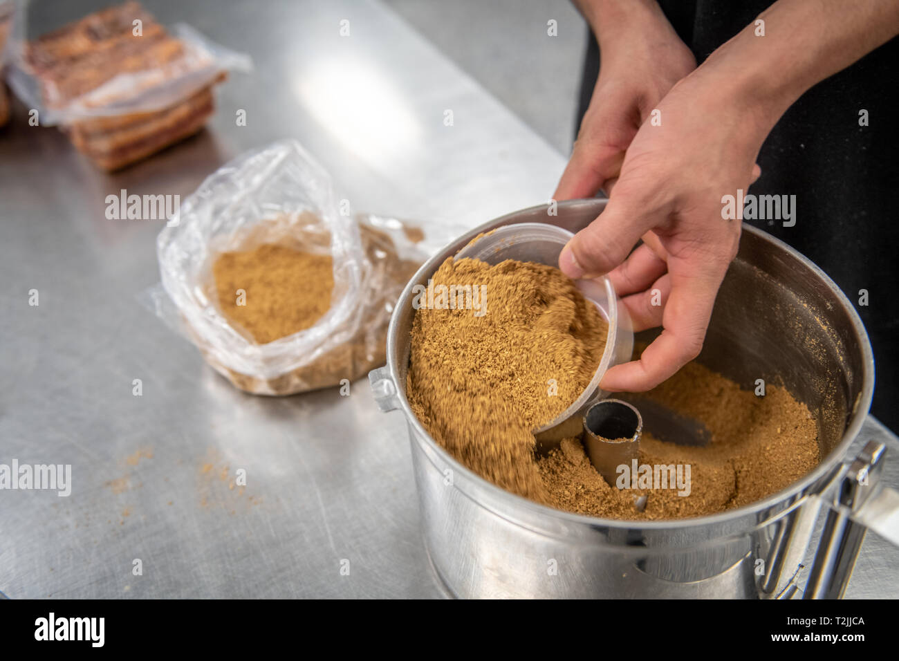 Man's hand scoops out spice with container to put into plastic bag ...