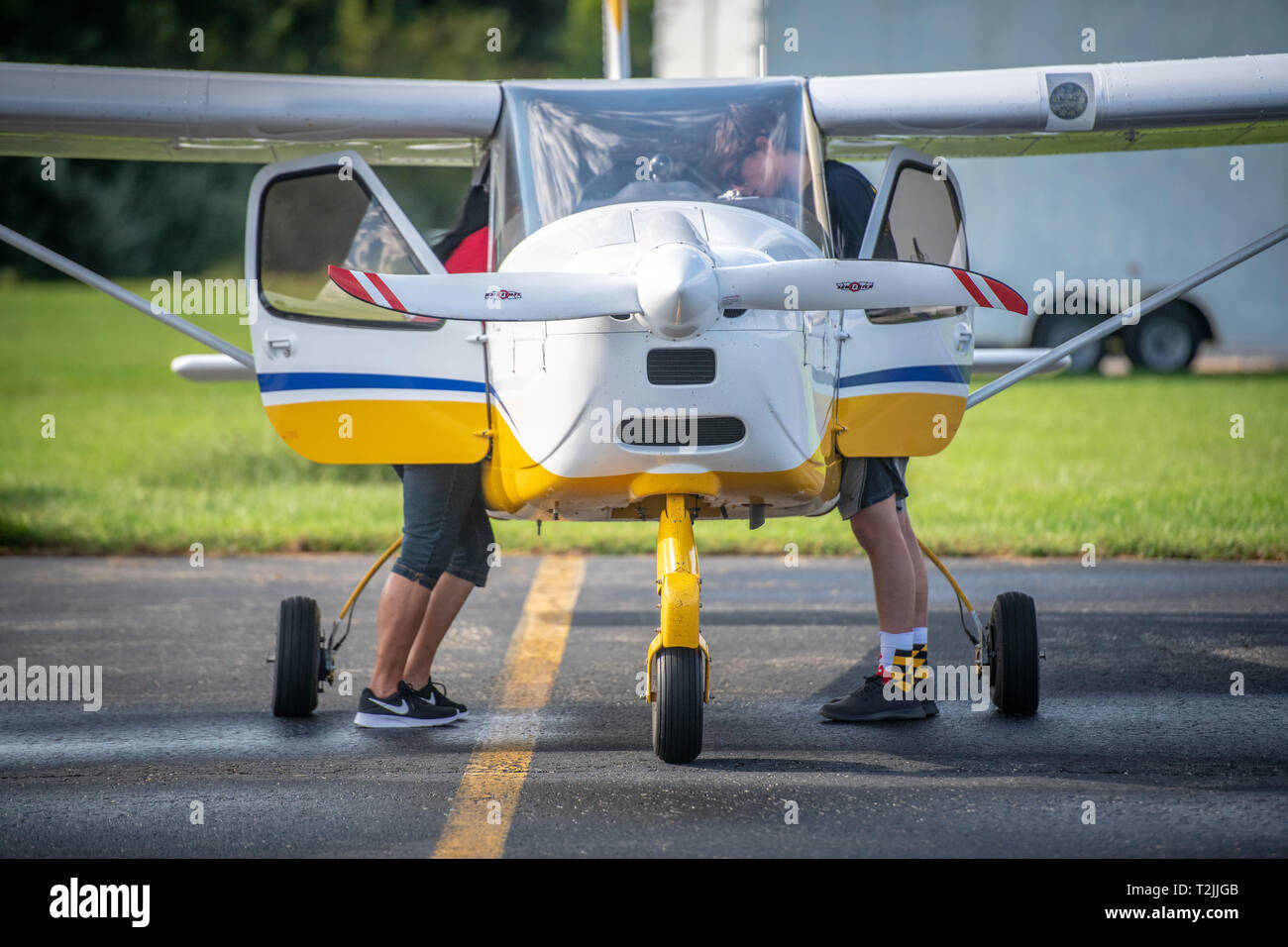 Front view of two people inspect cockpit of Tecnam P92 Eaglet airplane ...
