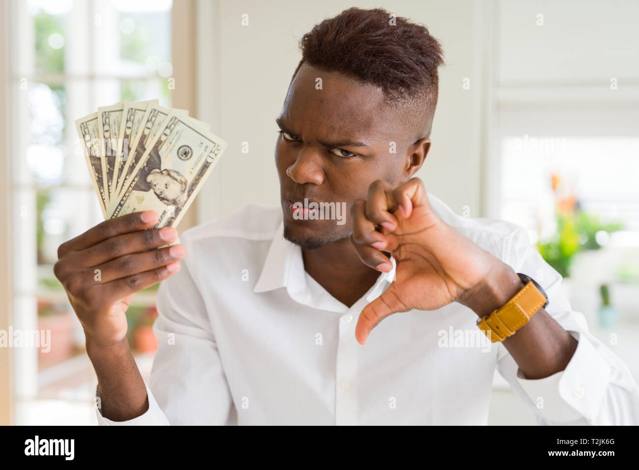 African american man holding twenty dollars bank notes with angry face ...