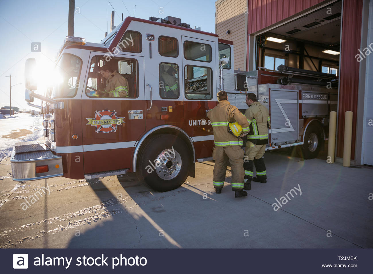 Firefighters at fire engine outside fire station Stock Photo - Alamy