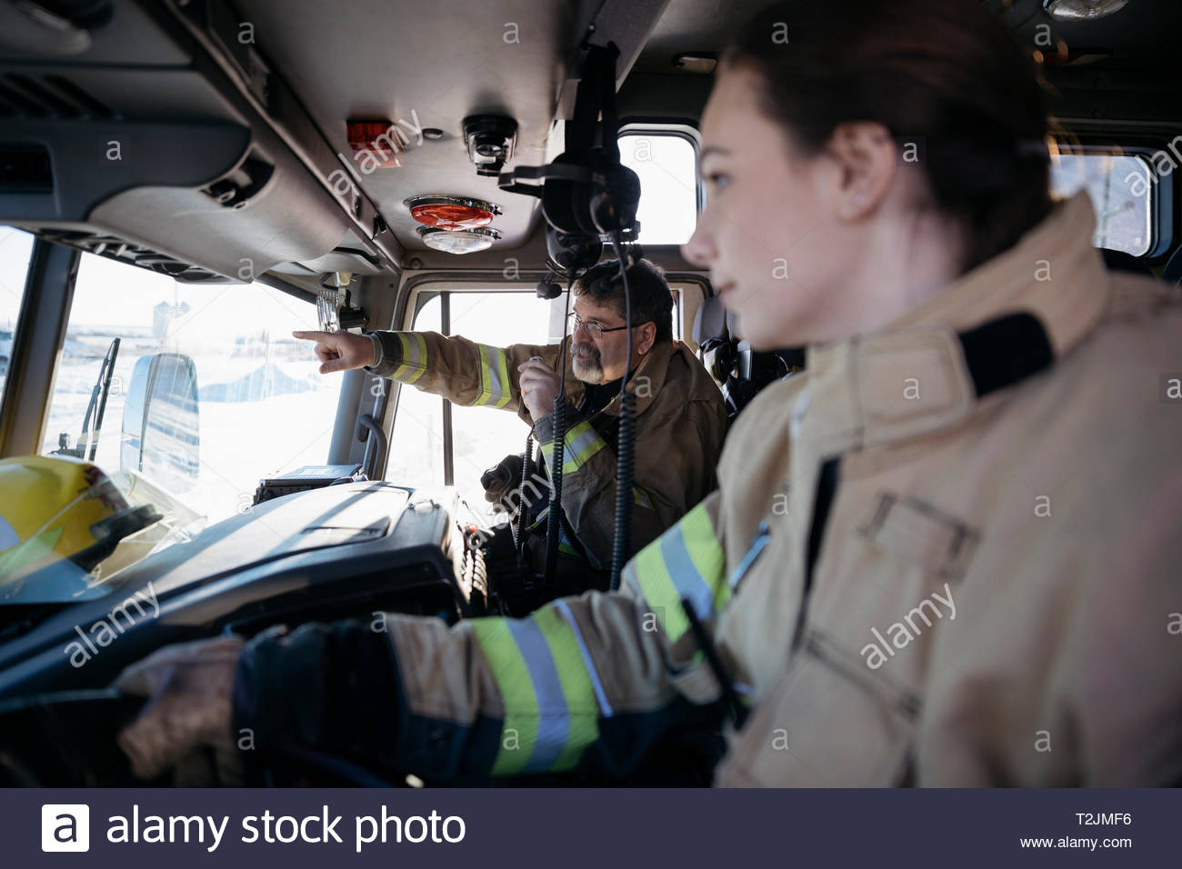 Firefighters driving fire engine Stock Photo - Alamy
