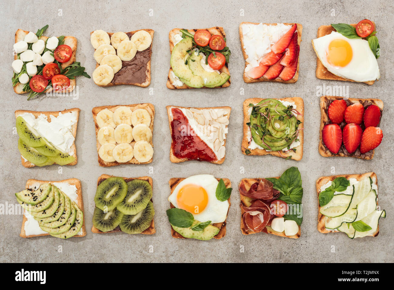 Top view of toasts with fried eggs, cut vegetables and fruits on ...