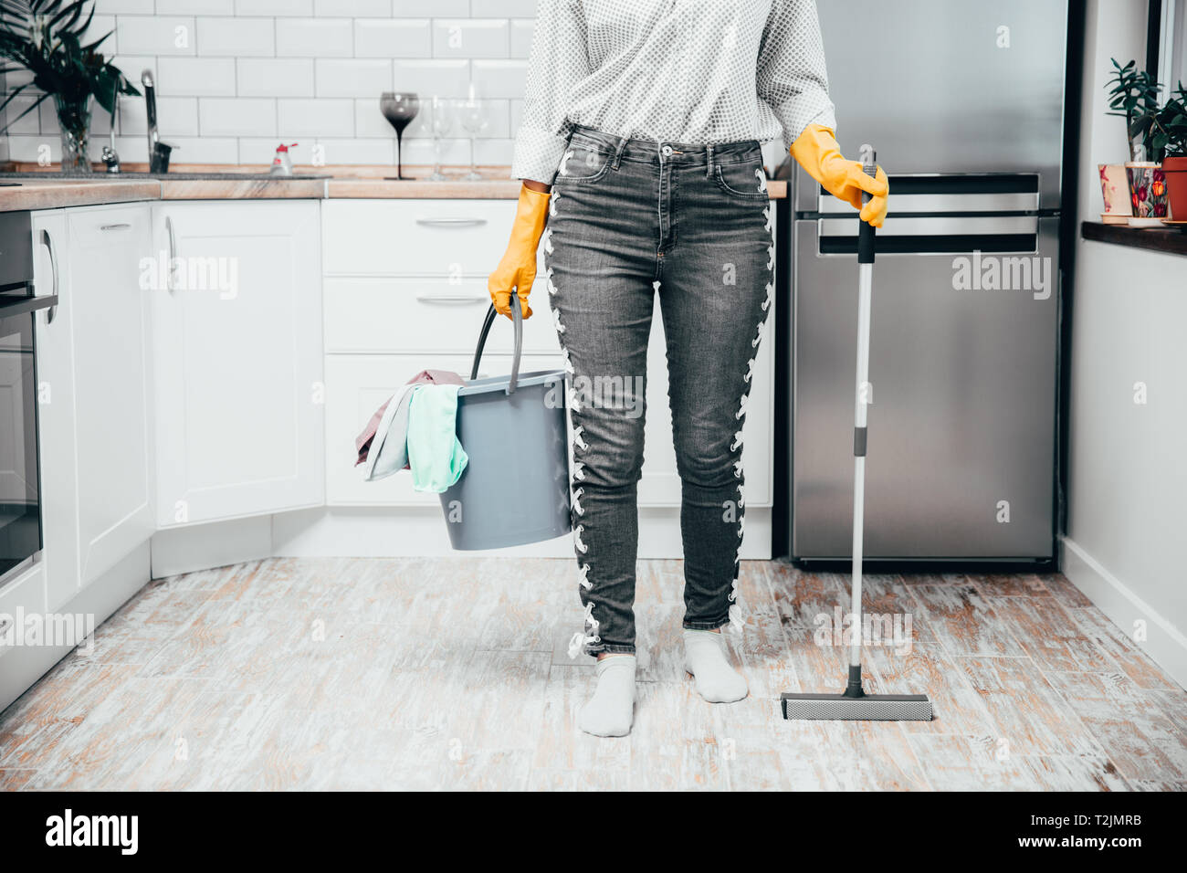 Woman holding mop and bucket with cleaning agents at home. cleaning the ...