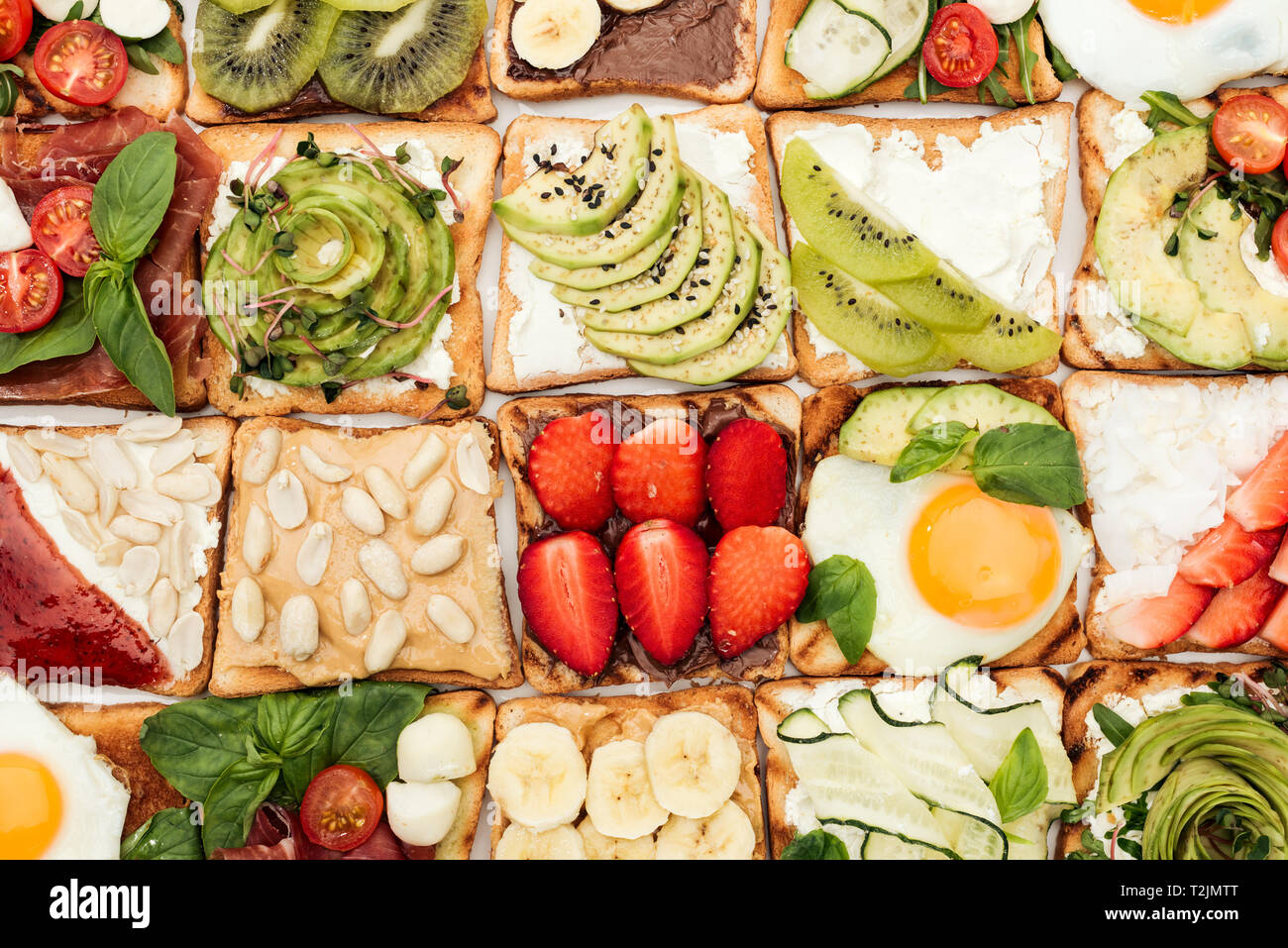 Top view of toasts with cut fruits, vegetables and peanuts Stock Photo ...