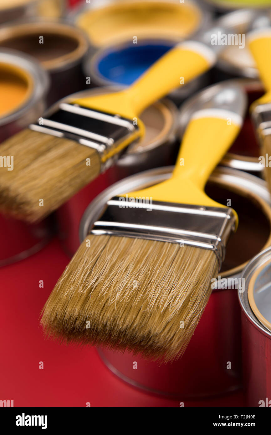 Open buckets with a paint and brush, red background Stock Photo - Alamy