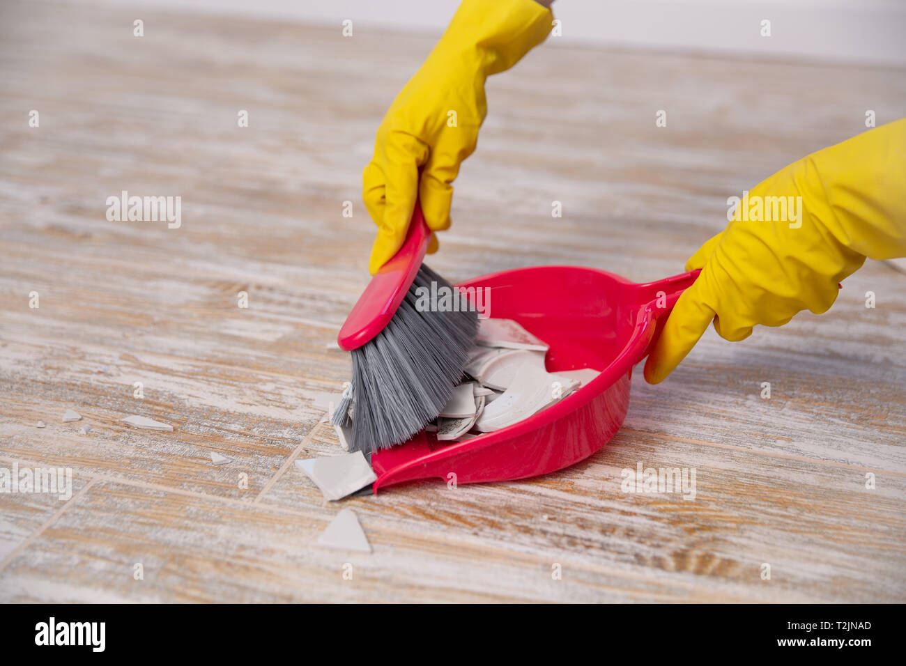 Clean up broken plate with broom and dustpan. sweep up the splinters ...