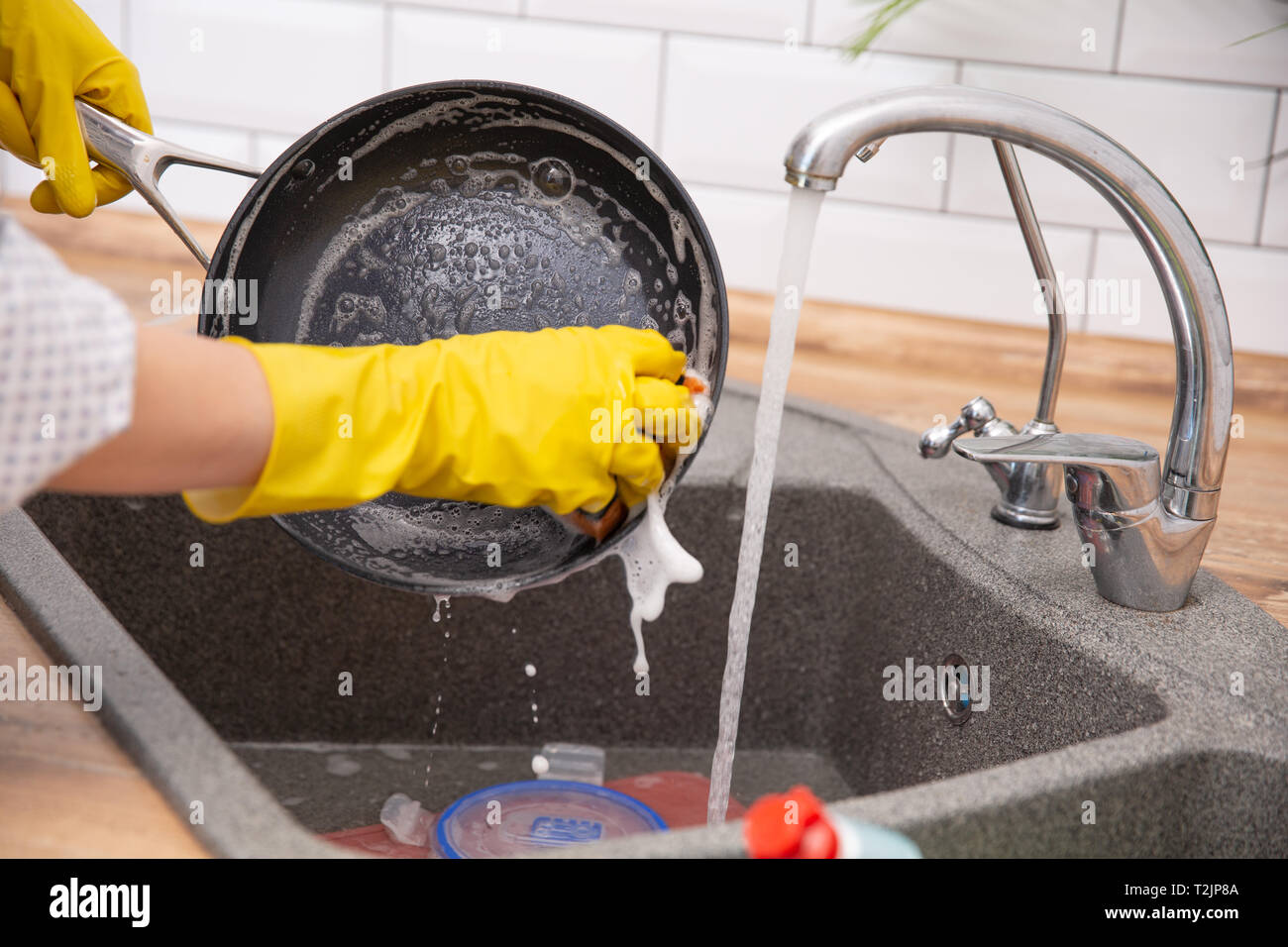 Female hand washing frying pan. Young housewife woman washing griddle ...