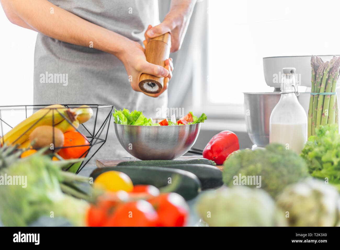 Young man chef cook cooking healthy meal salad with vegetables in the ...
