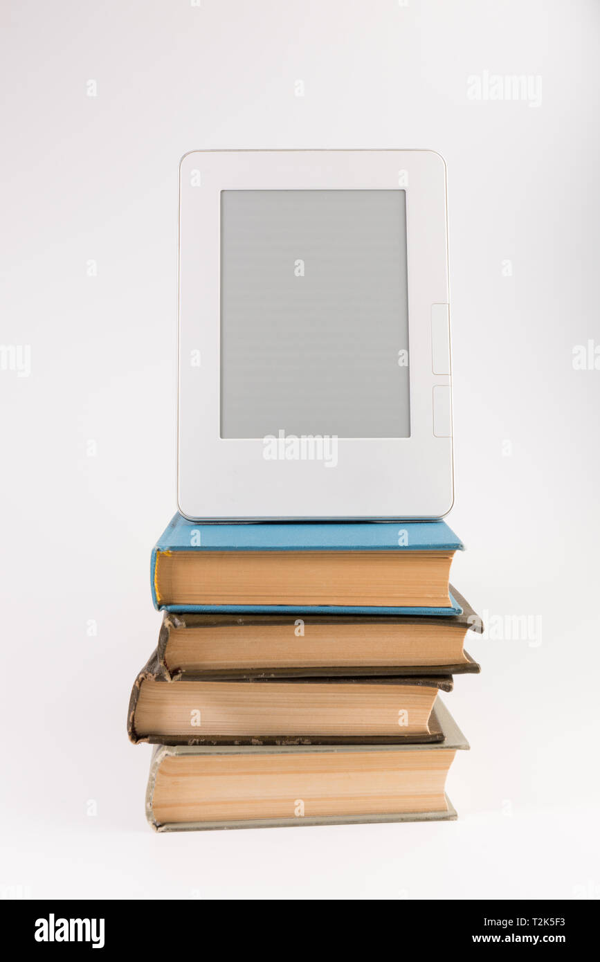 Electronic book on the top of the stack of regular old books isolated ...