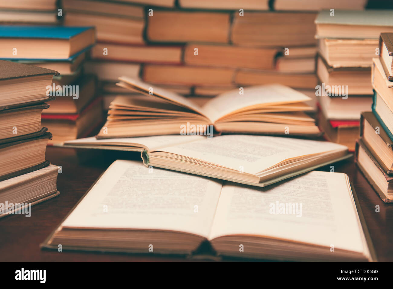 Old book in library with open textbook, stack piles of literature text ...