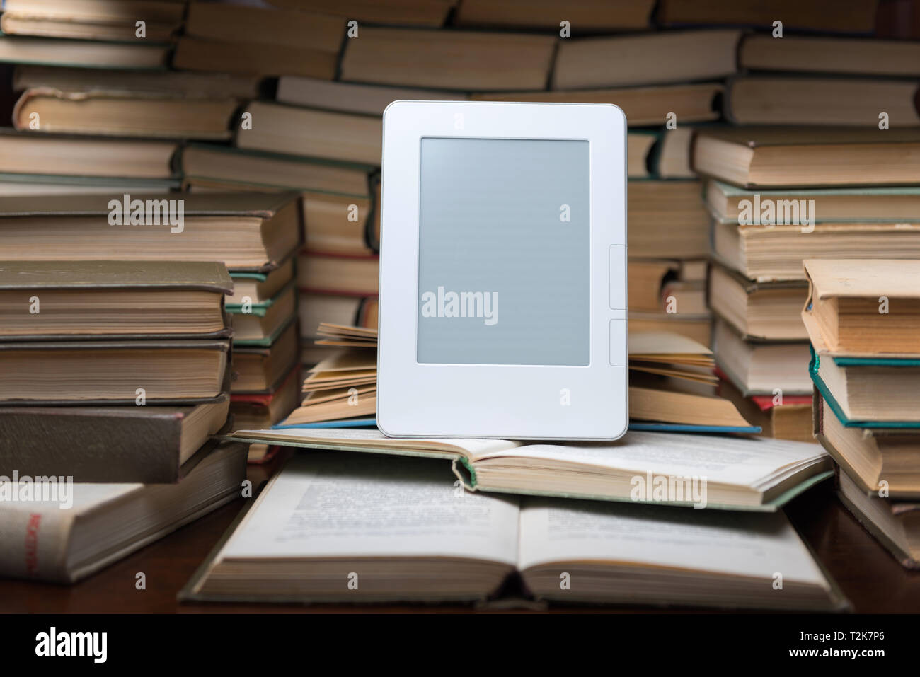 Electronic book on background of regular old books Stock Photo - Alamy