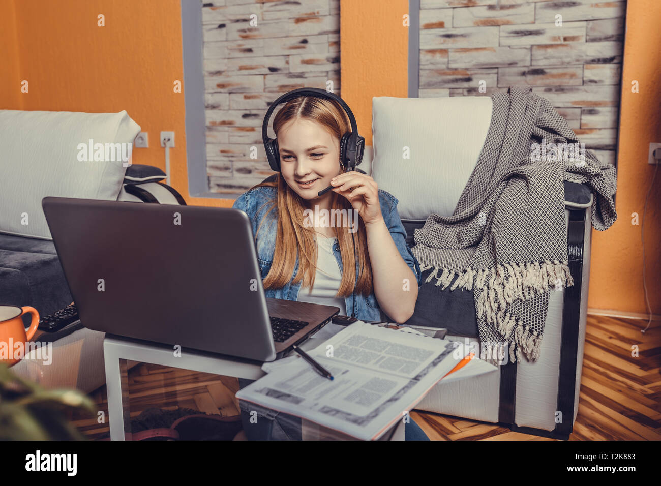 Happy young teenage girl in headphones speaking looking at laptop ... Happy young teenage girl in headphones speaking looking at laptop ...
