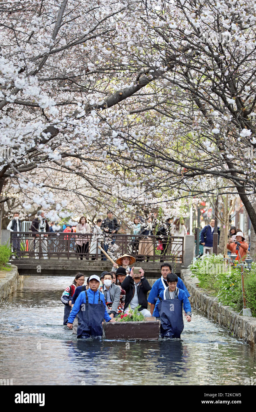 Visitors are towed in a boat down a small canal in Kiyamachi-dori ...