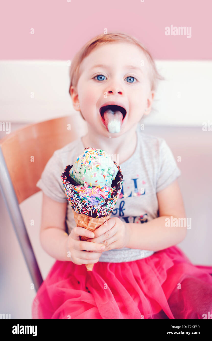 Cute funny Caucasian blonde babyl girl child with blue eyes eating ...