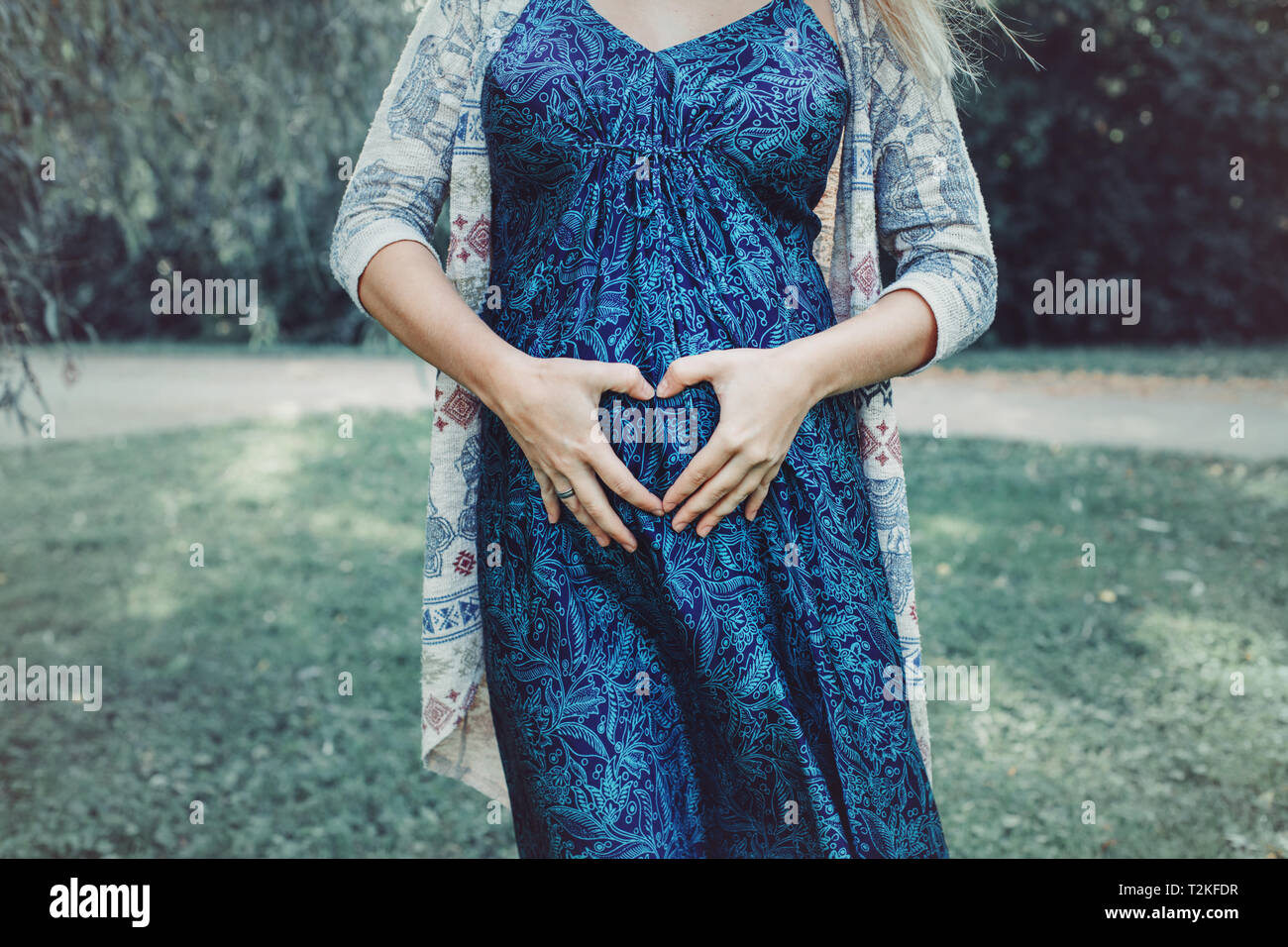 Closeup body of white Caucasian pregnant woman touching her belly and ...