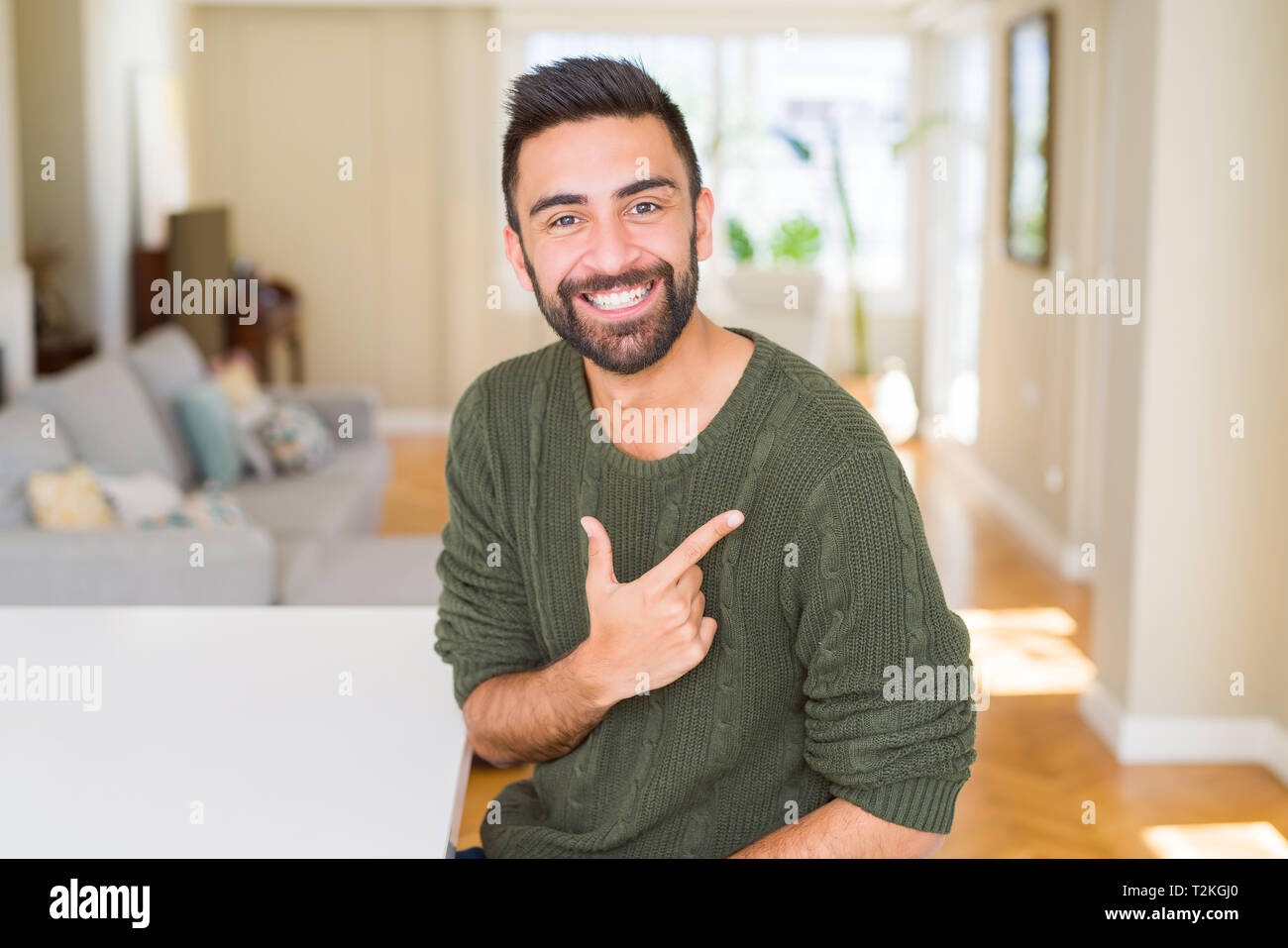 Handsome man pointing with arms and fingers, smiling cheerful with big ...