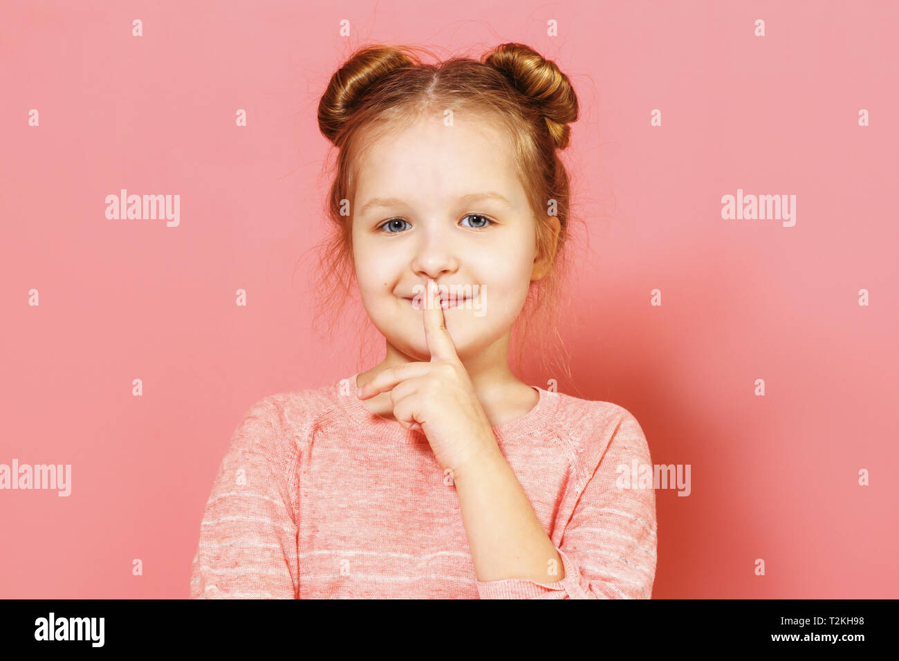 Closeup portrait of cute attractive little child girl showing shh sign ...