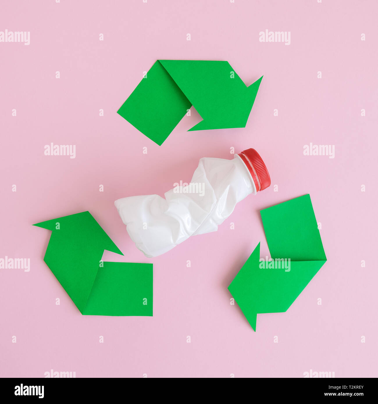 Recycle sign with plastic bottle isolated over pastel pink background ...