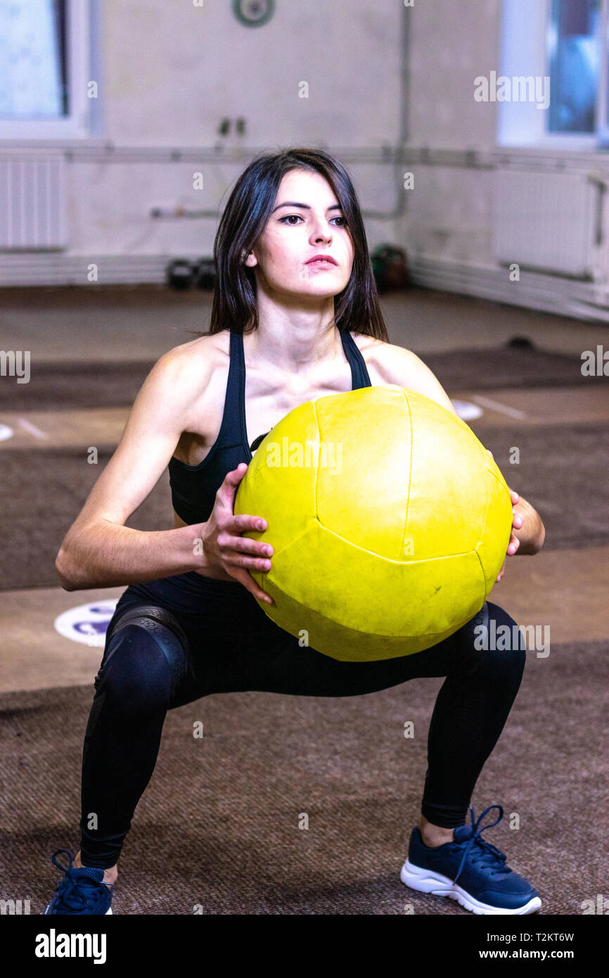 The girl is engaged with a crossfit ball in the gym Stock Photo - Alamy
