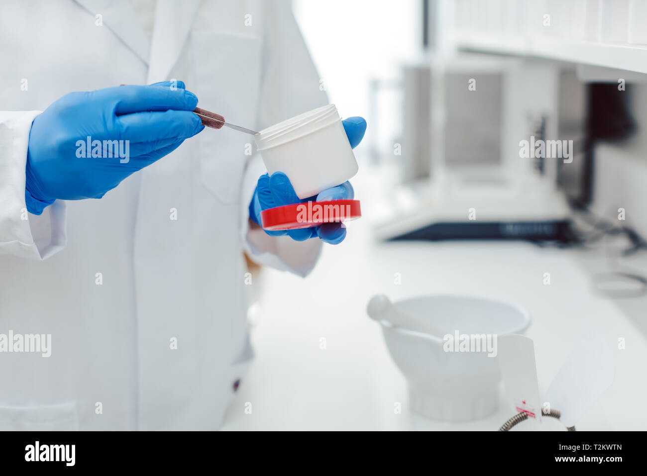 Pharmacist mixing drug on order in laboratory wearing protective ...