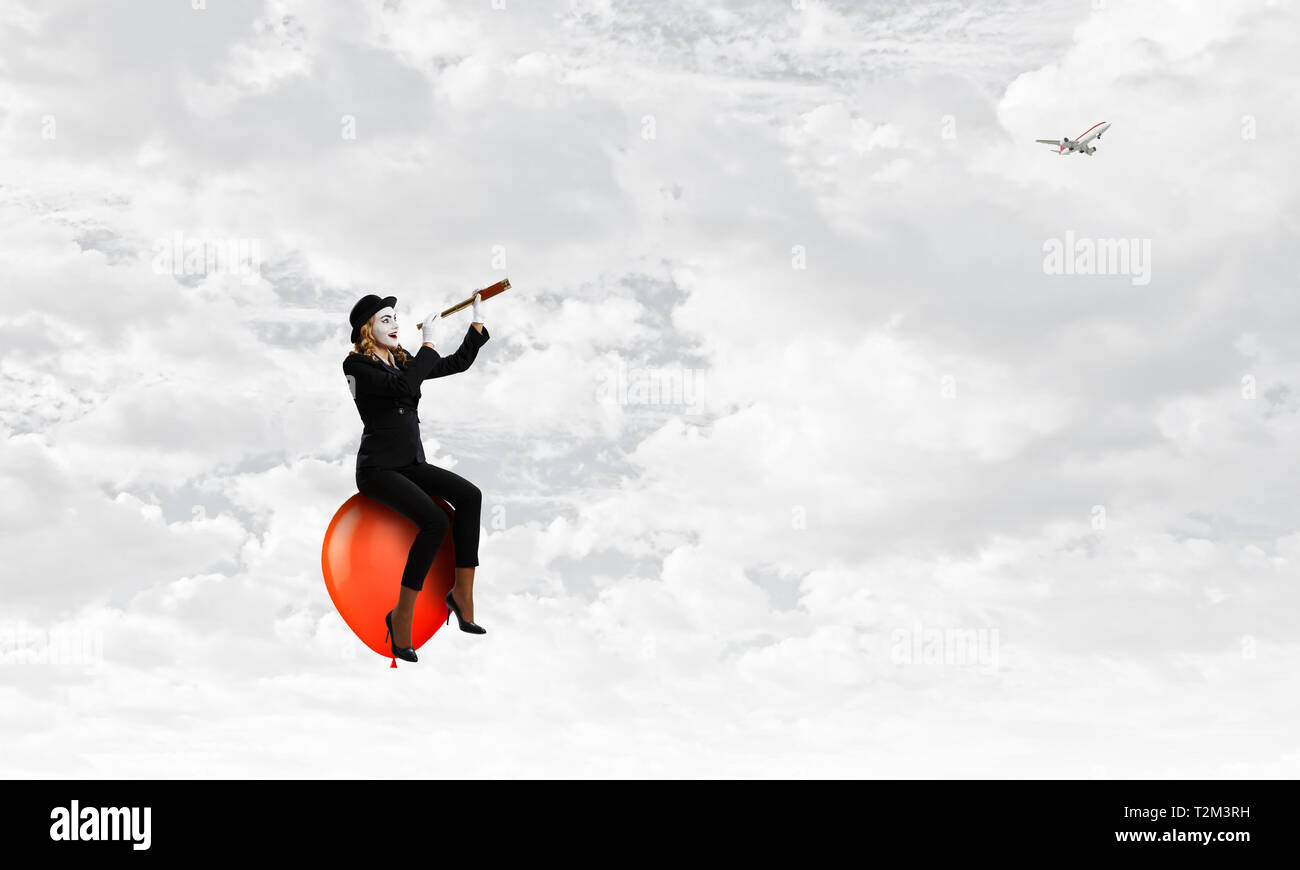Mime woman in black suit sitting on balloon. Mixed media Stock Photo ...