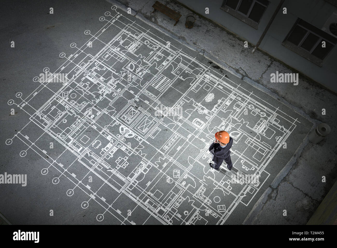 Top view of builder man and construction drawings on floor. Mixed media ...