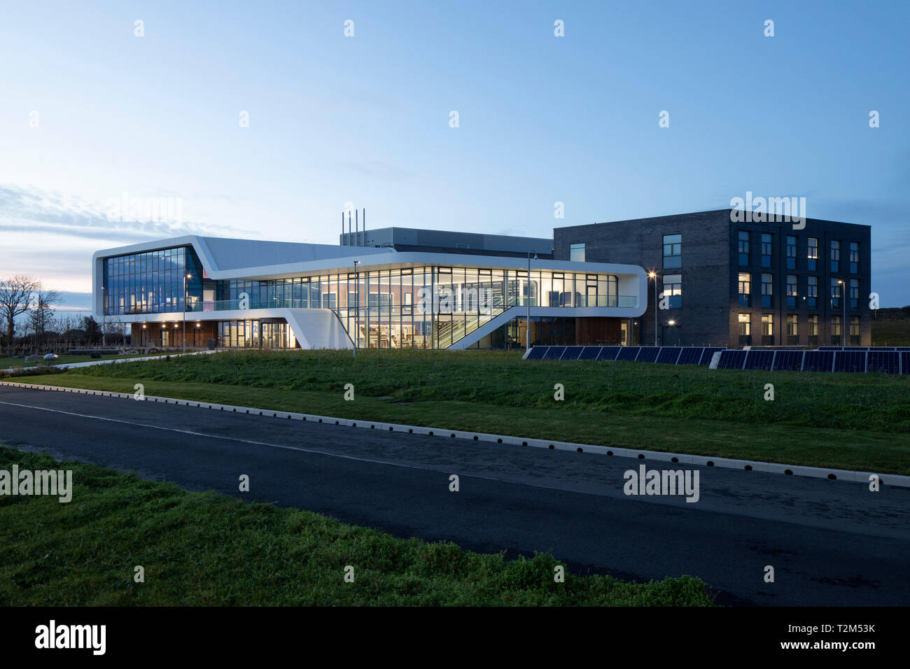 Wide view of front facade at dusk. Menai Science Parc, Bangor, United ...