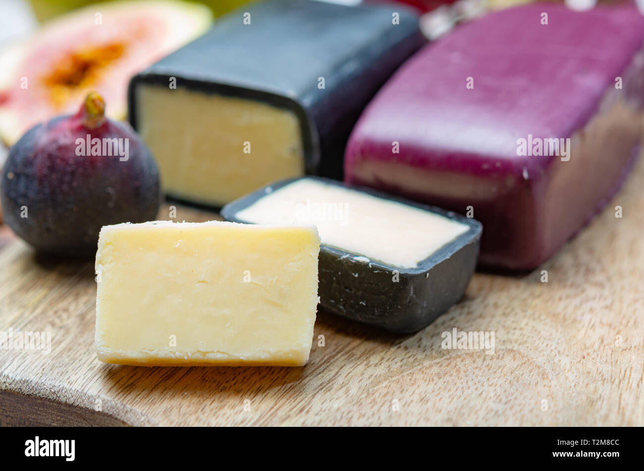 Mini black and dark red waxed cheddar cheeses made from West Country ...