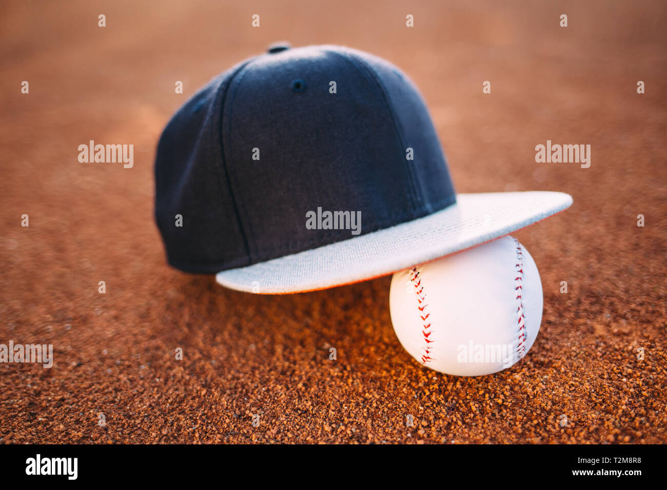Baseball cap and baseball ball on baseball field Stock Photo - Alamy