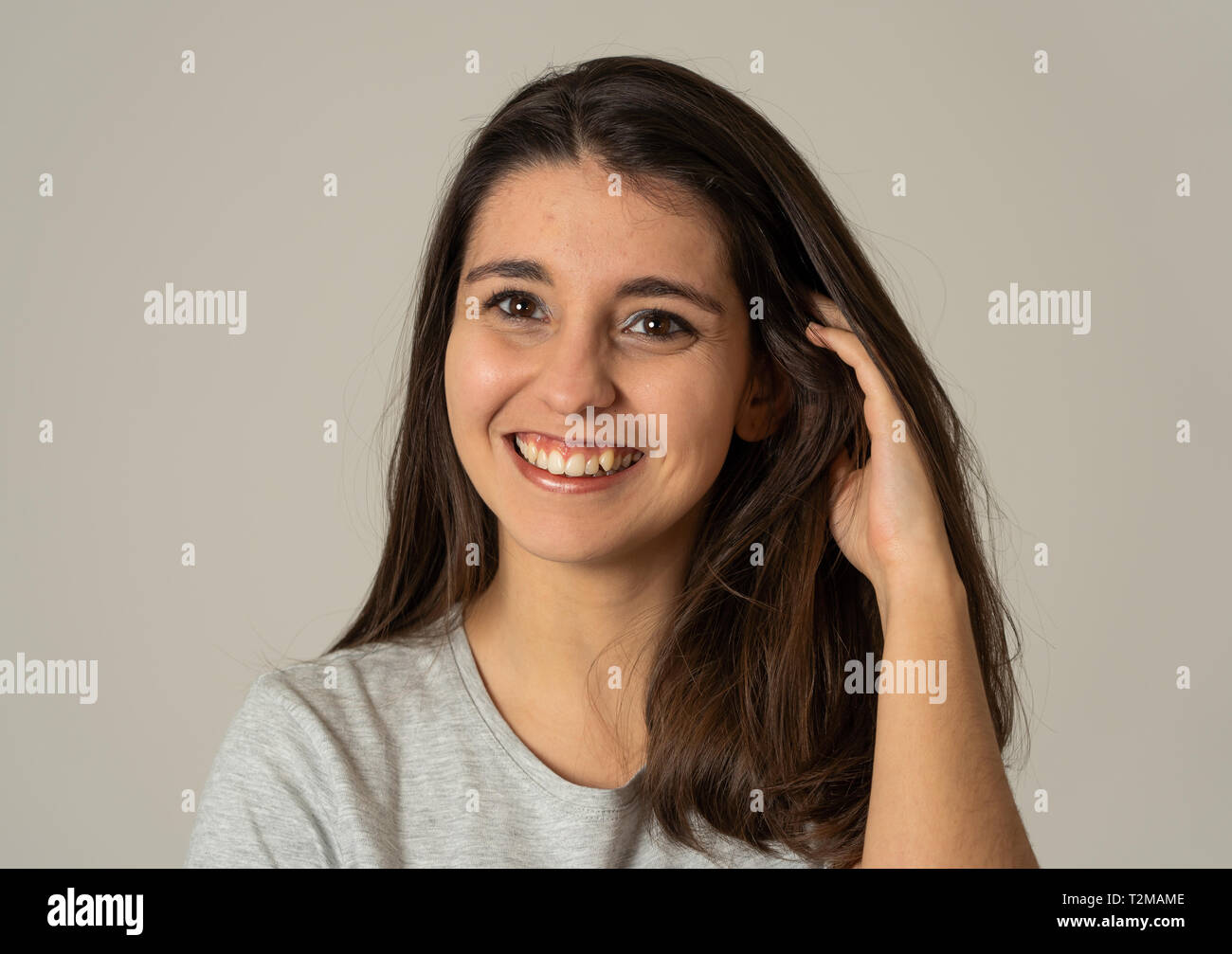 Close up portrait of smiling pretty young latin woman with happy face and beautiful hair posing ...