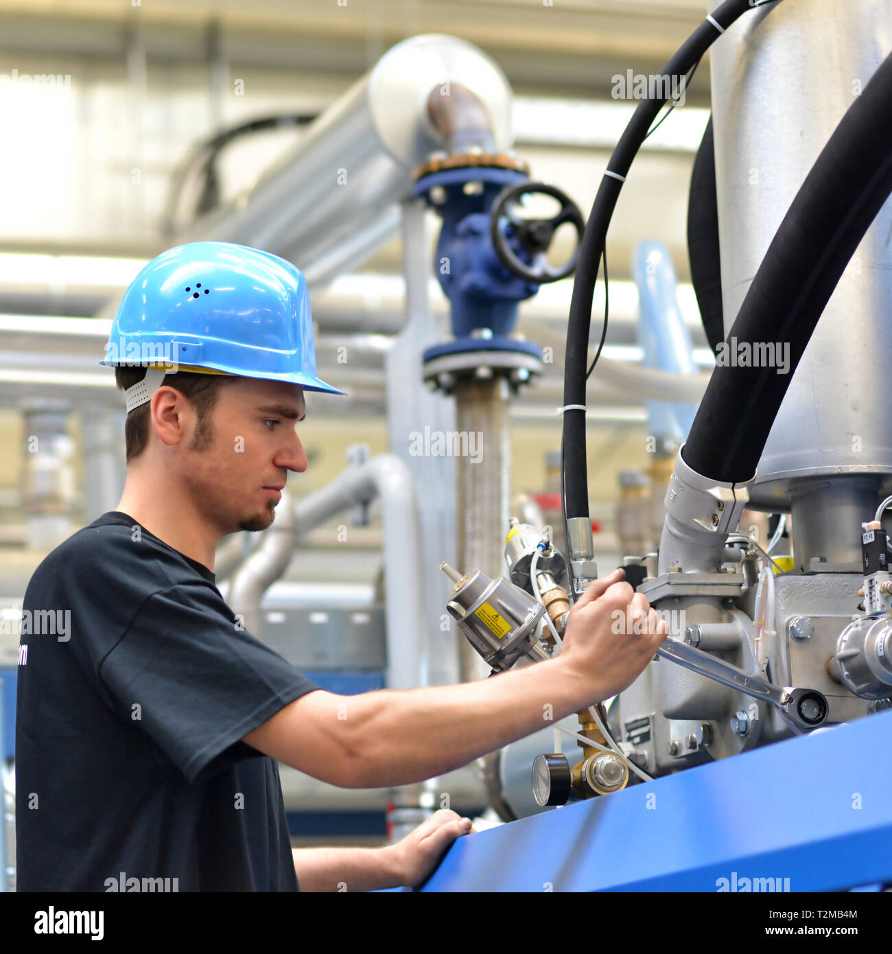 operator repairs a machine in an industrial plant with tools ...