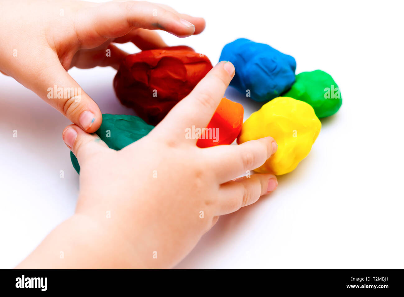 Child hands playing with play clay balls. White background Stock Photo ...