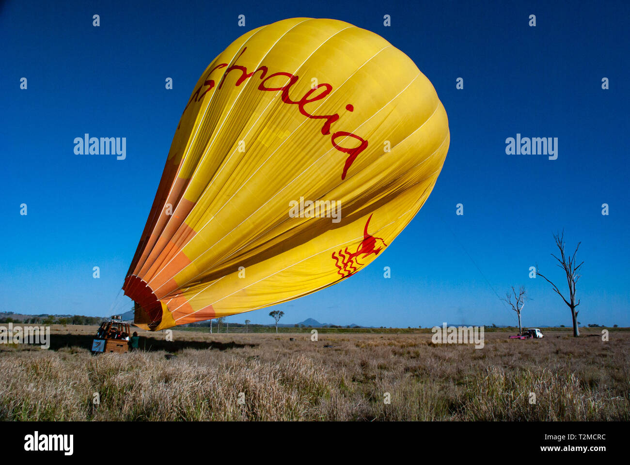 Hot air balloon landing in a large field Stock Photo - Alamy