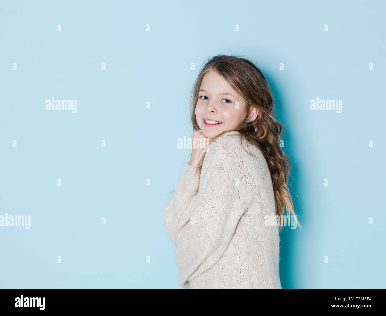 pretty and cool 9 year old girl with brown wool sweater posing in front ...