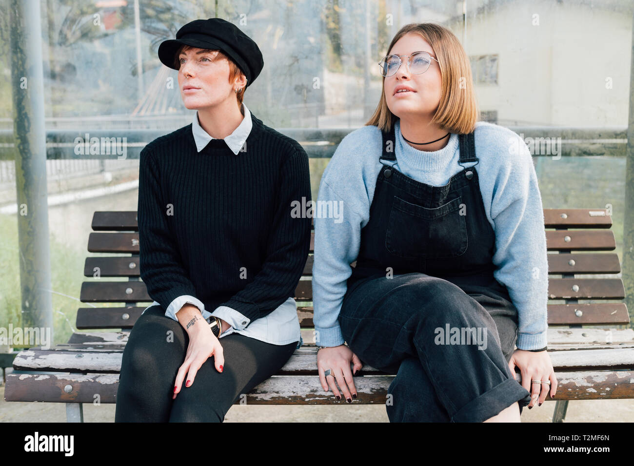 Friends sitting on park bench Stock Photo - Alamy